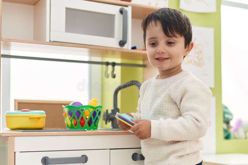 Adorable Hispanic Boy Playing with Play Kitchen Standing at ...