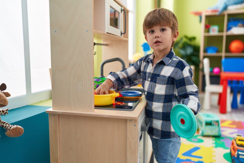 Adorable Hispanic Boy Playing with Play Kitchen Standing at ...