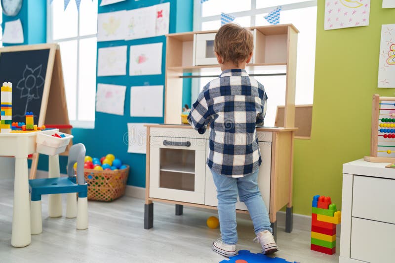 Adorable Hispanic Boy Playing with Play Kitchen Standing at ...