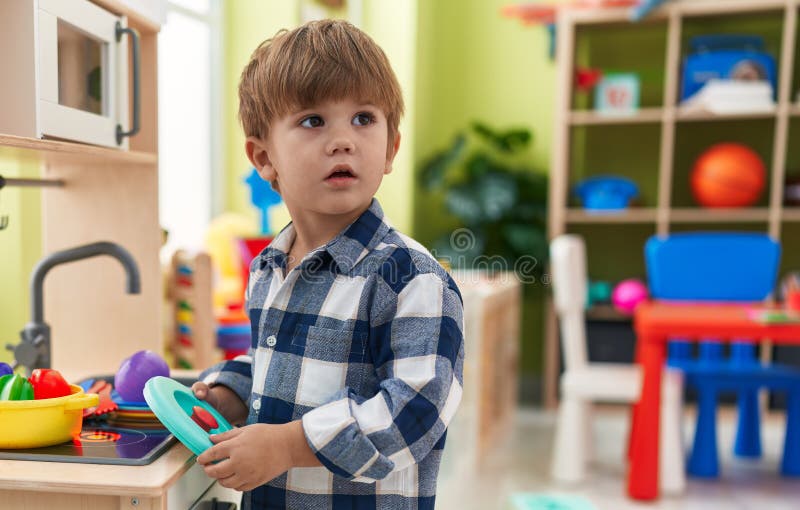 Adorable Hispanic Boy Playing with Play Kitchen Standing at ...