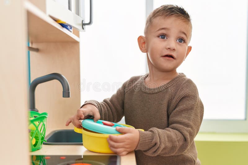 Adorable Hispanic Boy Playing with Play Kitchen Standing at ...