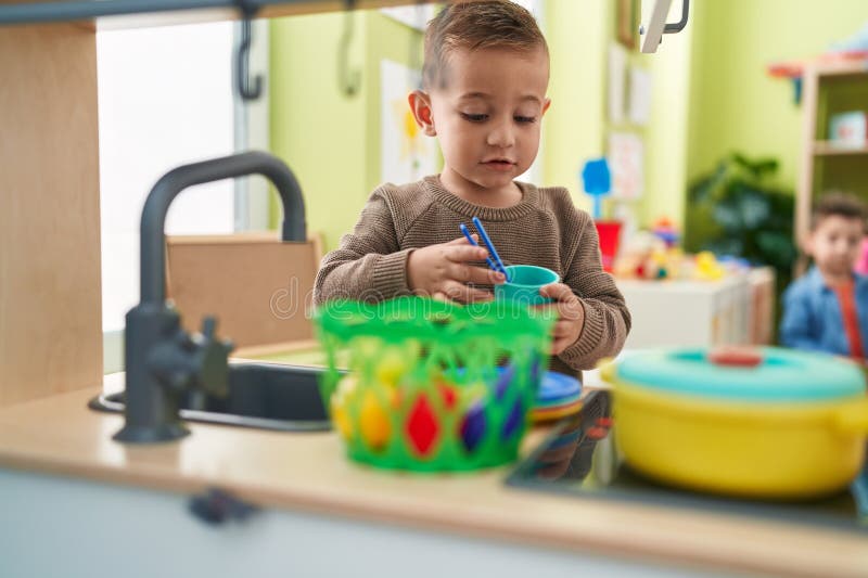 Adorable Hispanic Boy Playing with Play Kitchen Standing at ...