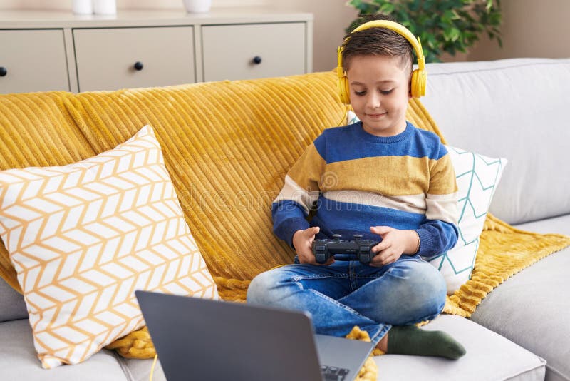Adorable Hispanic Boy Playing Video Game Sitting on Sofa at Home Stock ...