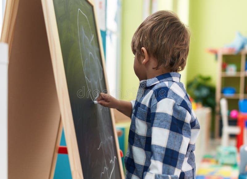 Adorable Hispanic Boy Preschool Student Drawing on Blackboard at ...