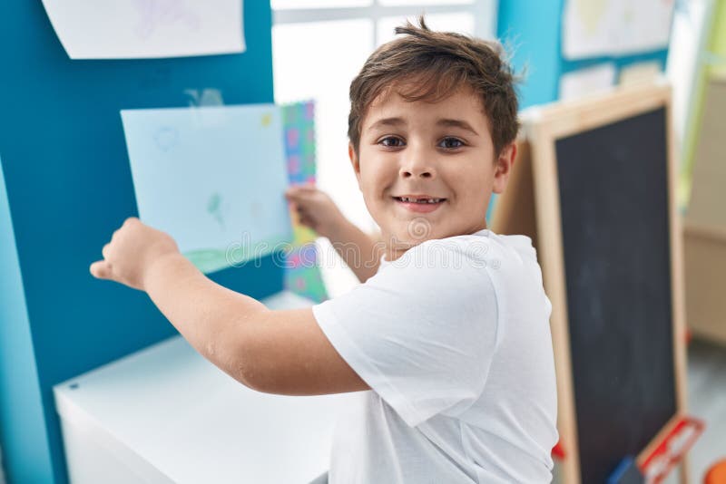 Adorable Hispanic Boy Preschool Student Hanging Draw on Wall at ...
