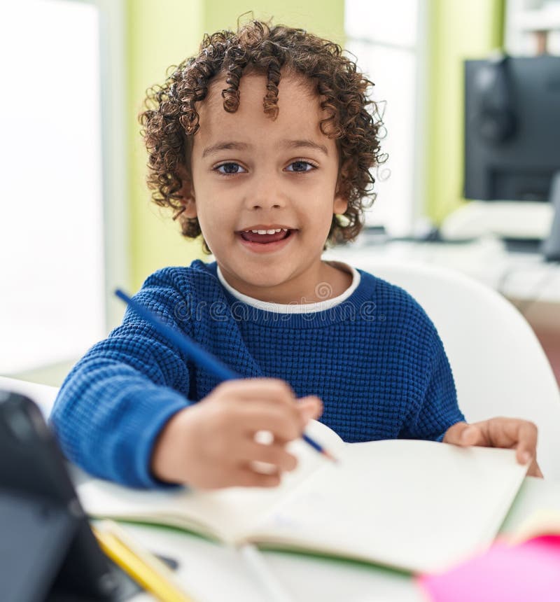 Adorable Hispanic Boy Preschool Student Sitting on Table Drawing on ...