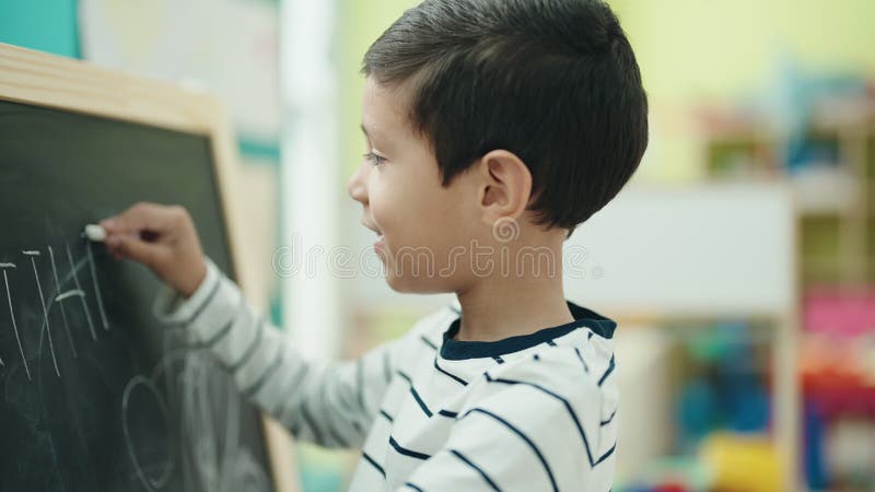Adorable Hispanic Boy Preschool Student Writing on Blackboard at ...