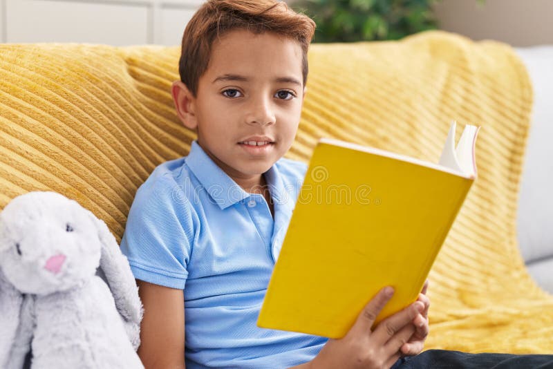 Adorable Hispanic Boy Reading Book Sitting on Sofa at Home Stock Image ...