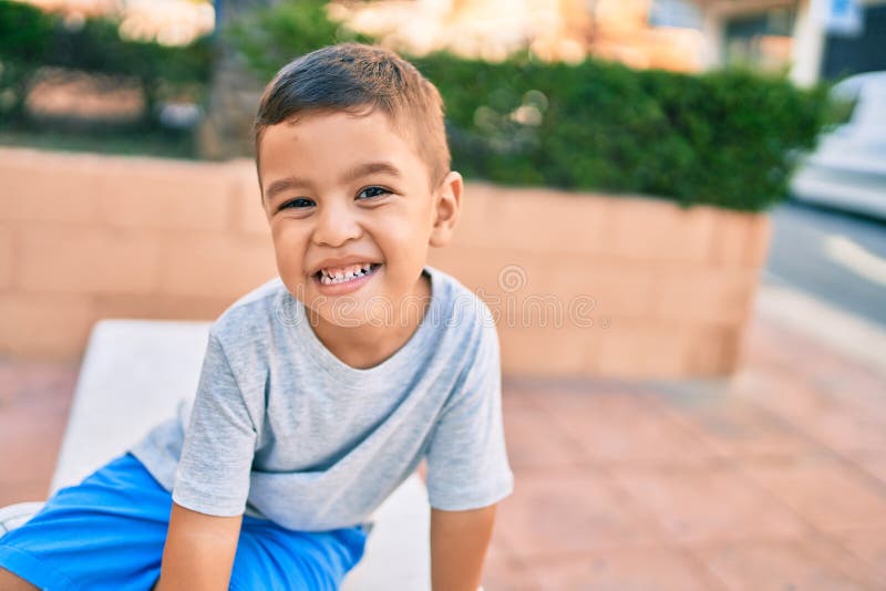 Adorable Hispanic Boy Smiling Happy Sitting on the Bench at the Park ...