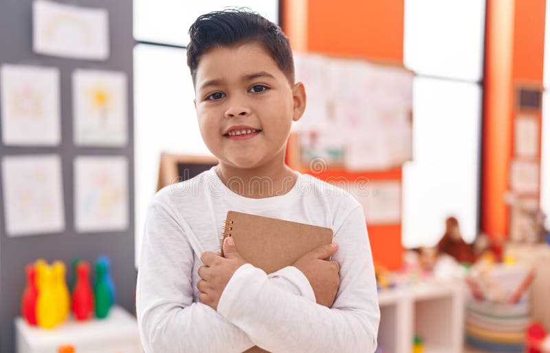 Adorable Hispanic Boy Standing with Hugging Notebook at Kindergarten ...