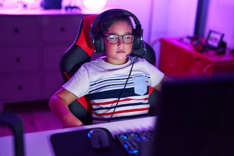 Adorable Hispanic Boy Streamer Sitting on Table with Serious Expression ...