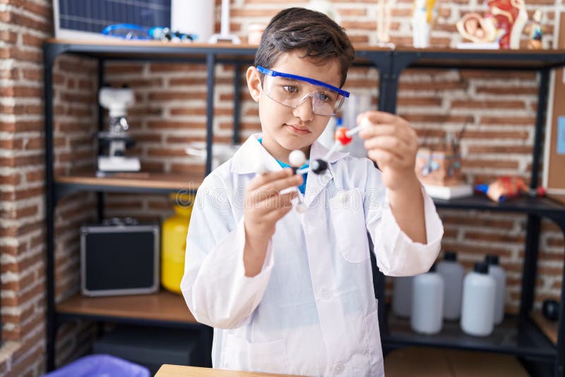 Adorable Hispanic Boy Student Looking Molecules at Laboratory Classroom ...