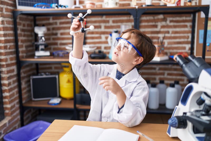 Adorable Hispanic Boy Student Looking Molecules at Laboratory Classroom ...