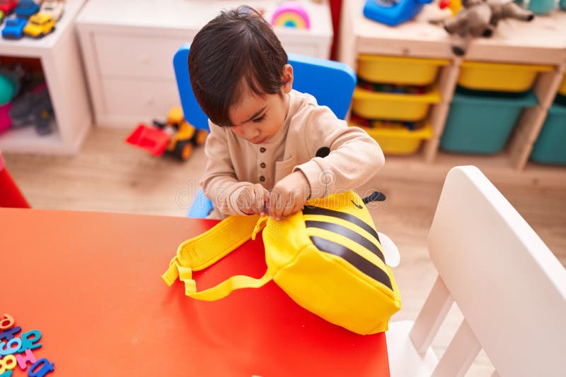 Adorable Hispanic Boy Student Opening Backpack Sitting on Table at ...