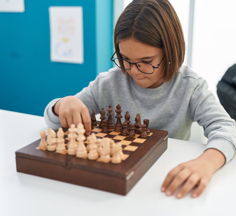 Adorable Hispanic Boy Student Playing Chess at Classroom Stock Photo ...