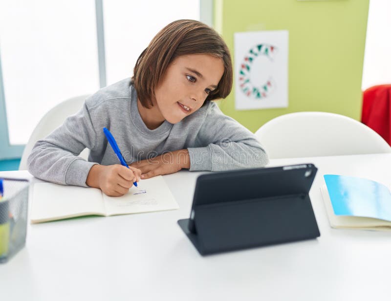 Adorable Hispanic Boy Student Sitting on Table Doing Homework at ...