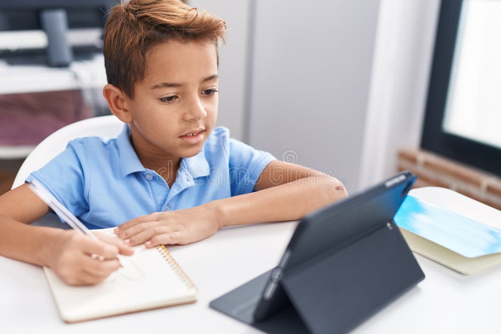 Adorable Hispanic Boy Student Sitting on Table Doing Homework at ...