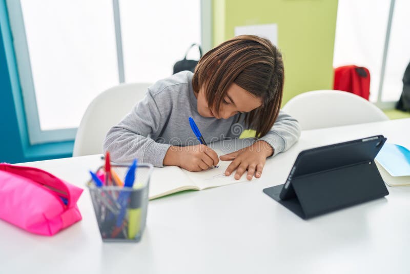 Adorable Hispanic Boy Student Sitting on Table Doing Homework at ...