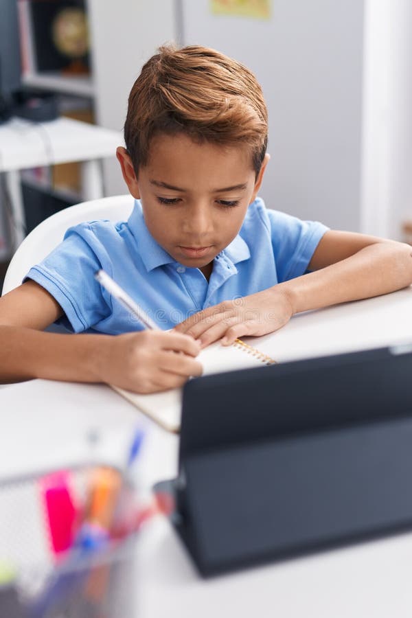 Adorable Hispanic Boy Student Sitting on Table Doing Homework at ...