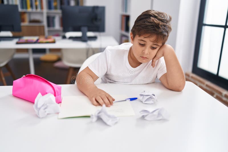Adorable Hispanic Boy Student Sitting on Table with Worried Expression ...