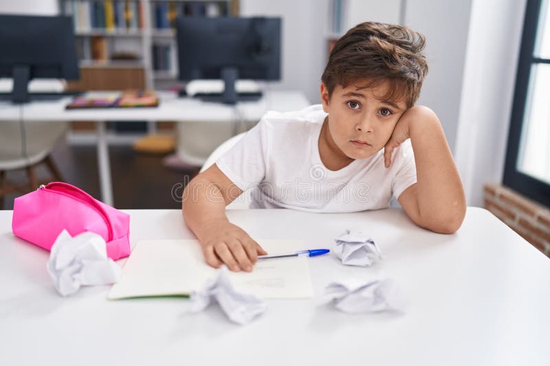 Adorable Hispanic Boy Student Sitting on Table with Worried Expression ...