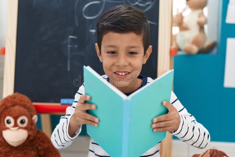 Adorable Hispanic Boy Student Smiling Confident Reading Book at ...