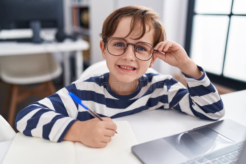 Adorable Hispanic Boy Student Using Computer Writing on Notebook at ...