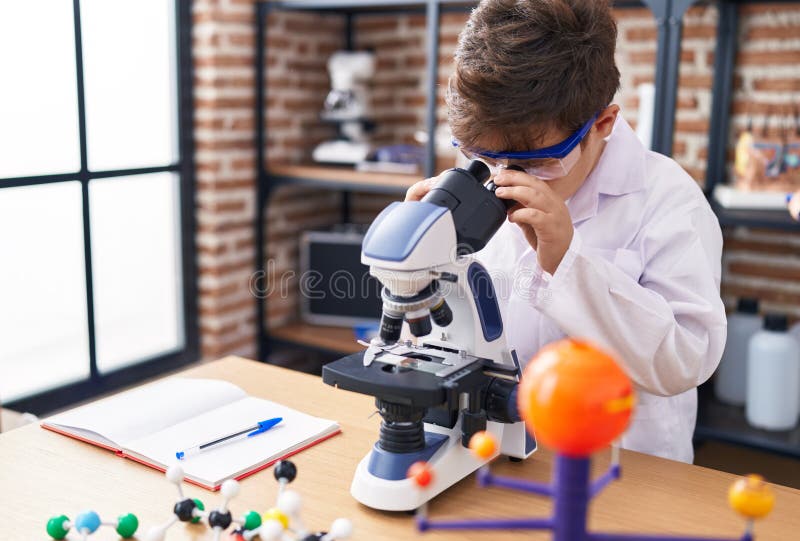 Adorable Hispanic Boy Student Using Microscope at Laboratory Classroom ...