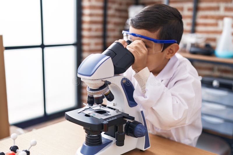 Adorable Hispanic Boy Student Using Microscope at Laboratory Classroom ...