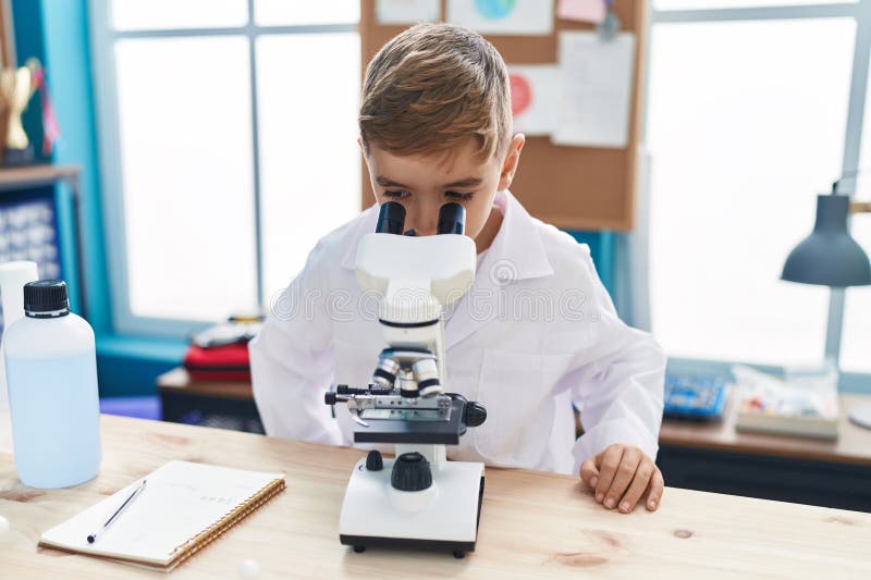 Adorable Hispanic Boy Student Using Microscope at Laboratory Classroom ...