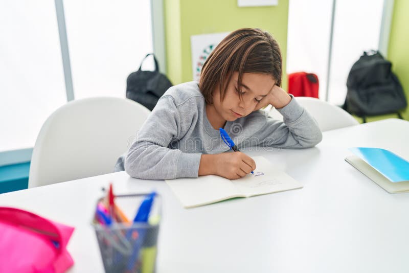 Adorable Hispanic Boy Student Writing on Notebook at Classroom Stock ...