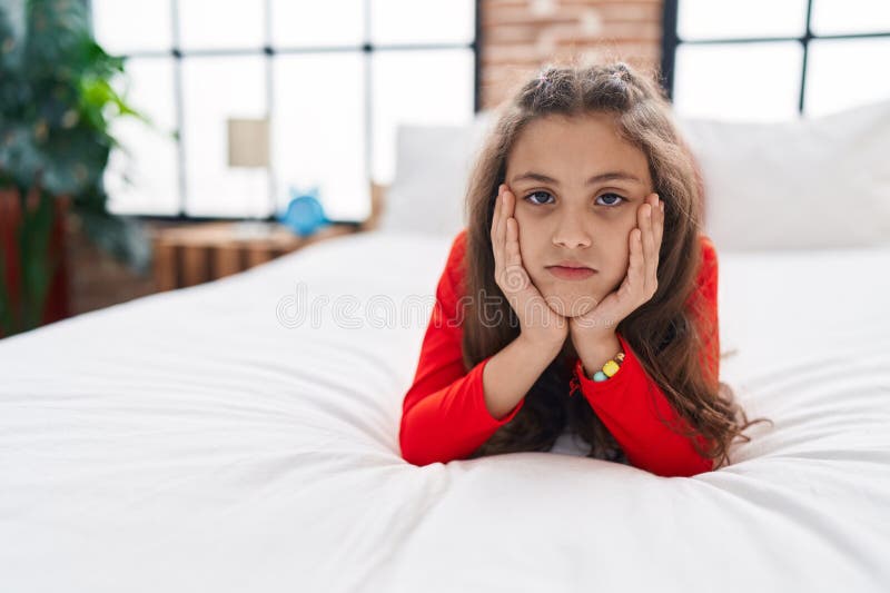 Adorable Hispanic Girl Lying on the Bed with Sad Expression at Bedroom ...