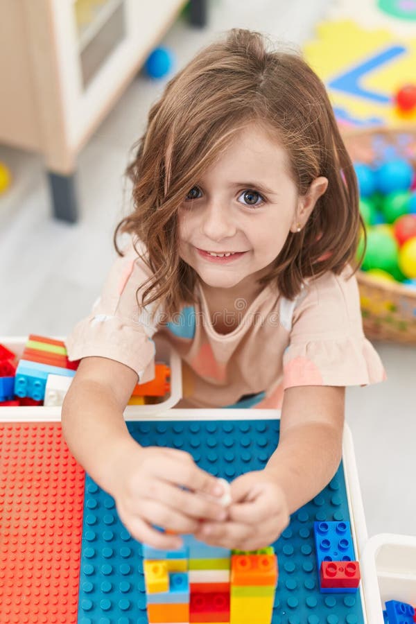Adorable Hispanic Girl Playing with Construction Blocks Sitting on Table at Kindergarten Stock ...