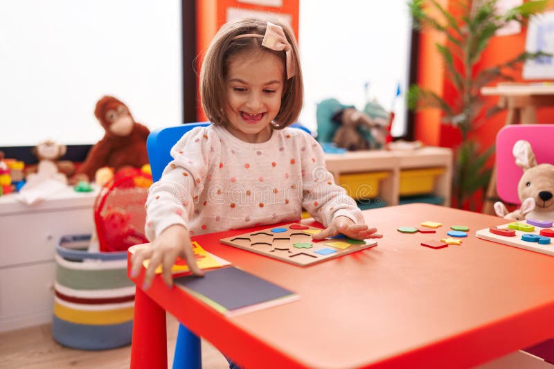 Adorable Hispanic Girl Playing with Maths Puzzle Game Sitting on Table ...