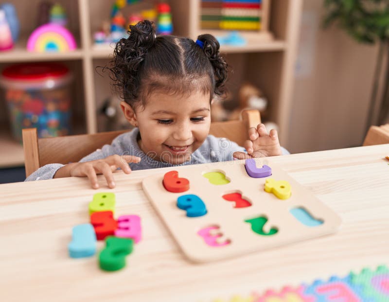 Adorable Hispanic Girl Playing with Maths Puzzle Game Sitting on Table ...
