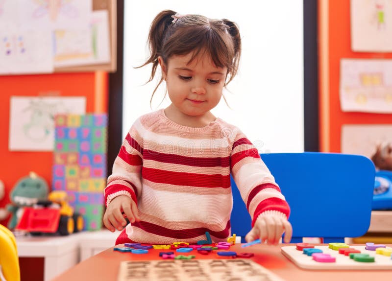 Adorable Hispanic Girl Playing with Maths Puzzle Game Standing at ...