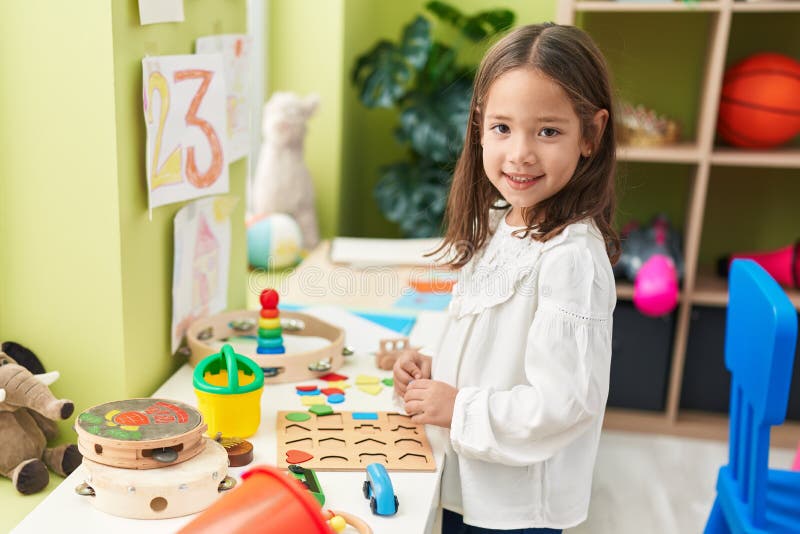 Adorable Hispanic Girl Playing with Maths Puzzle Game Standing at ...