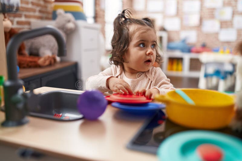 Adorable Hispanic Girl Playing with Play Kitchen Standing at ...