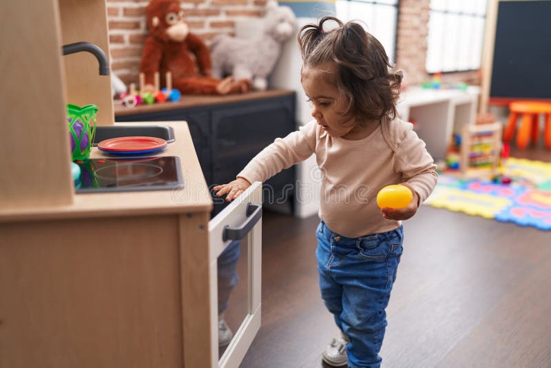 Adorable Hispanic Girl Playing with Play Kitchen Standing at ...
