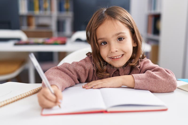 Adorable Hispanic Girl Student Sitting on Table Doing Homework at ...