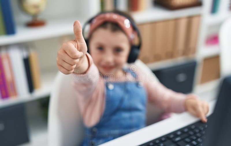 Adorable Hispanic Girl Student Using Computer Doing Thumb Up Gesture at ...