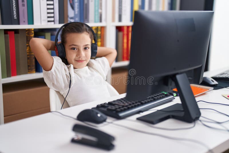 Adorable Hispanic Girl Student Using Computer and Headphones Relaxed ...