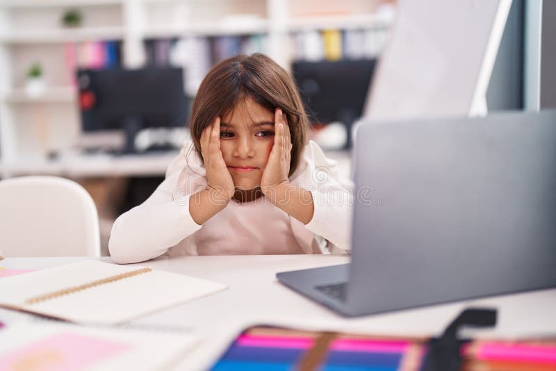 Adorable Hispanic Girl Student Using Laptop with Worried Expression at ...