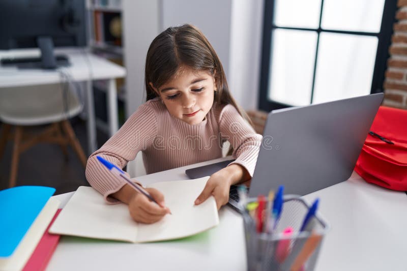 Adorable Hispanic Girl Student Using Laptop Writing on Notebook at ...