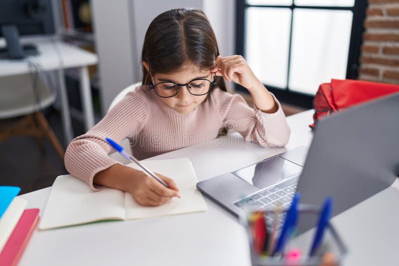 Adorable Hispanic Girl Student Using Laptop Writing on Notebook at ...