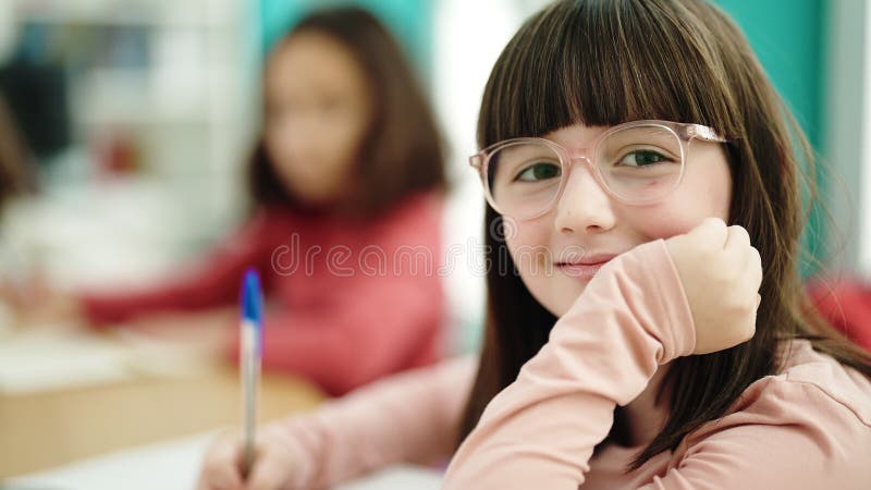 Adorable Hispanic Girl Student Writing on Notebook at Classroom Stock ...