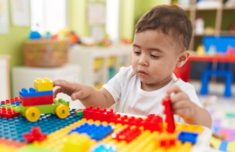 Adorable Hispanic Toddler Playing with Construction Blocks Sitting on ...