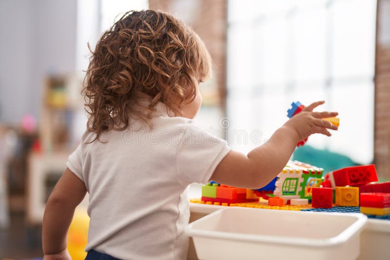 Adorable Hispanic Toddler Playing with Construction Blocks Standing at ...