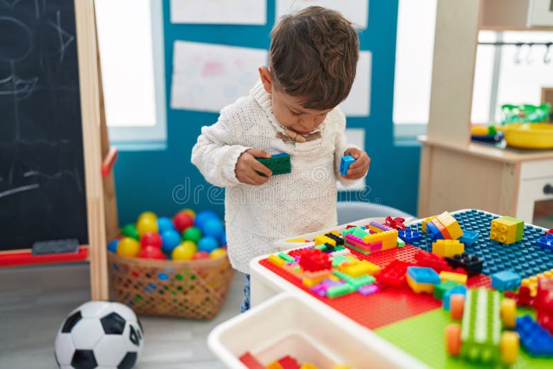 Adorable Hispanic Toddler Playing with Construction Blocks Standing at ...