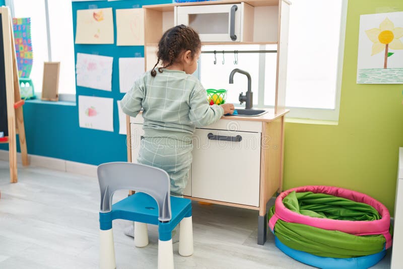 Adorable Hispanic Toddler Playing with Play Kitchen Standing at Kindergarten Stock Image - Image ...